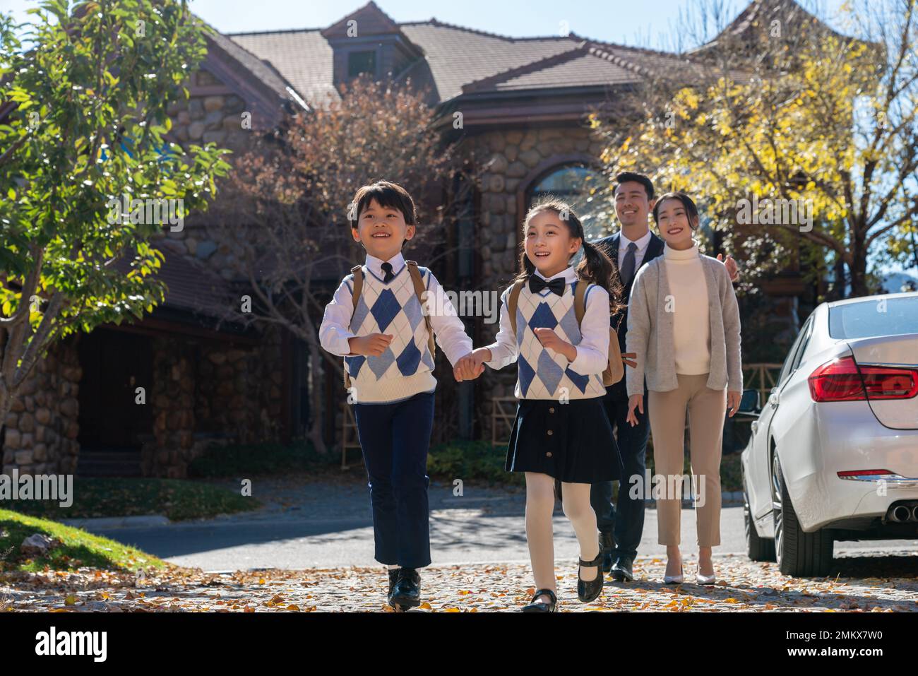 A young couple pick up the kids from school Stock Photo - Alamy