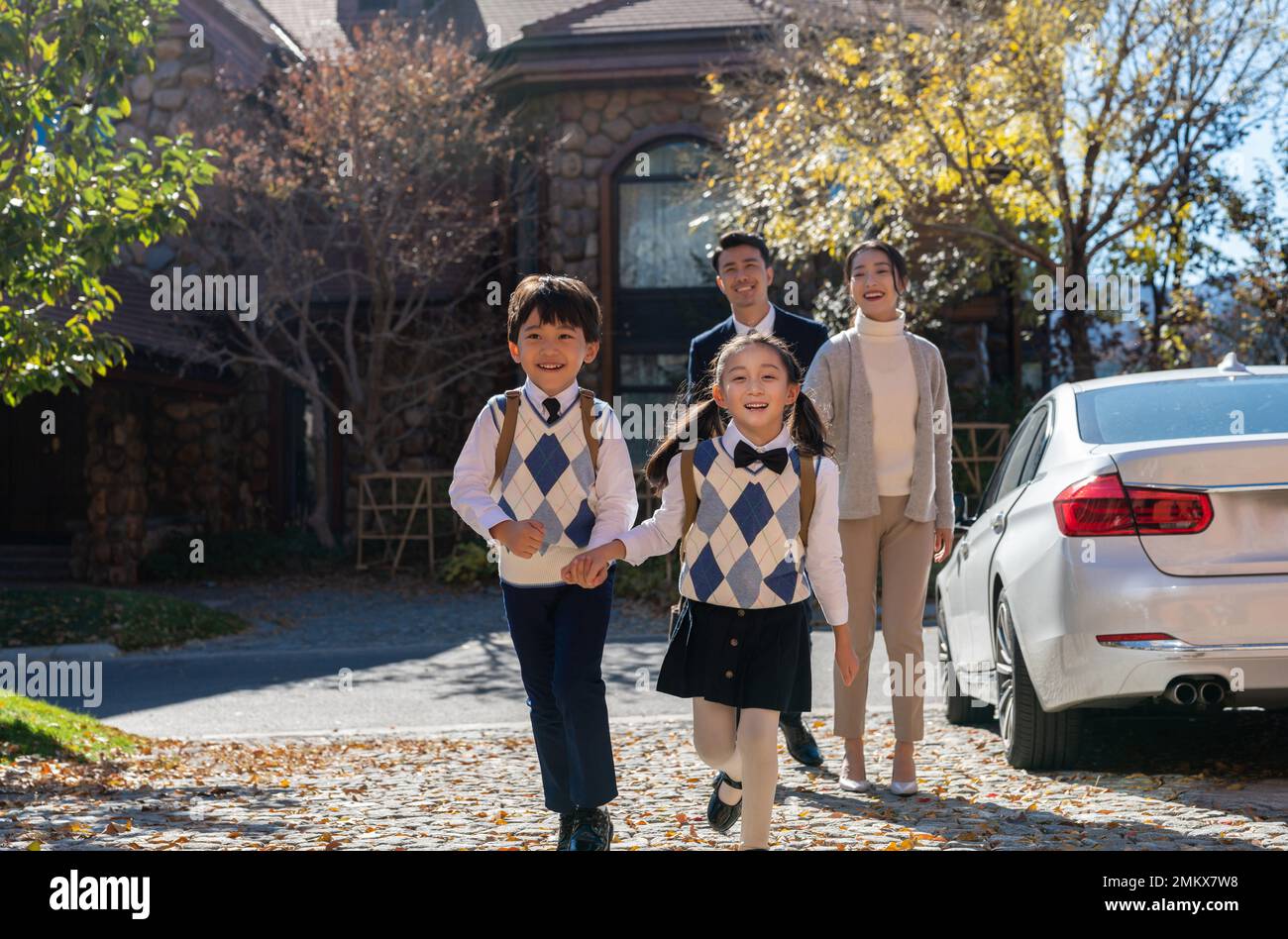 A young couple pick up the kids from school Stock Photo - Alamy