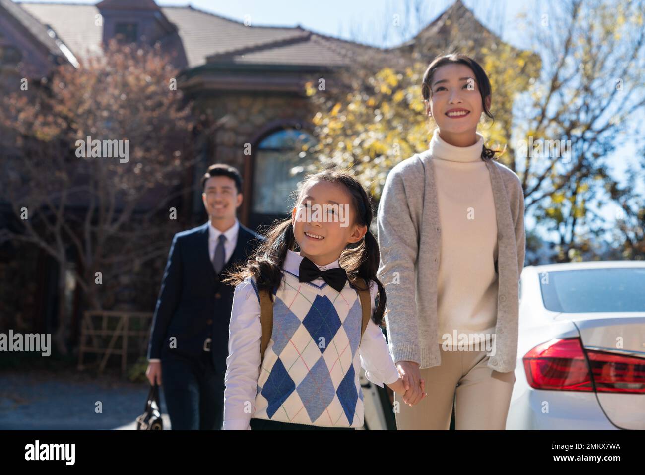 A young couple pick up the kids from school Stock Photo - Alamy