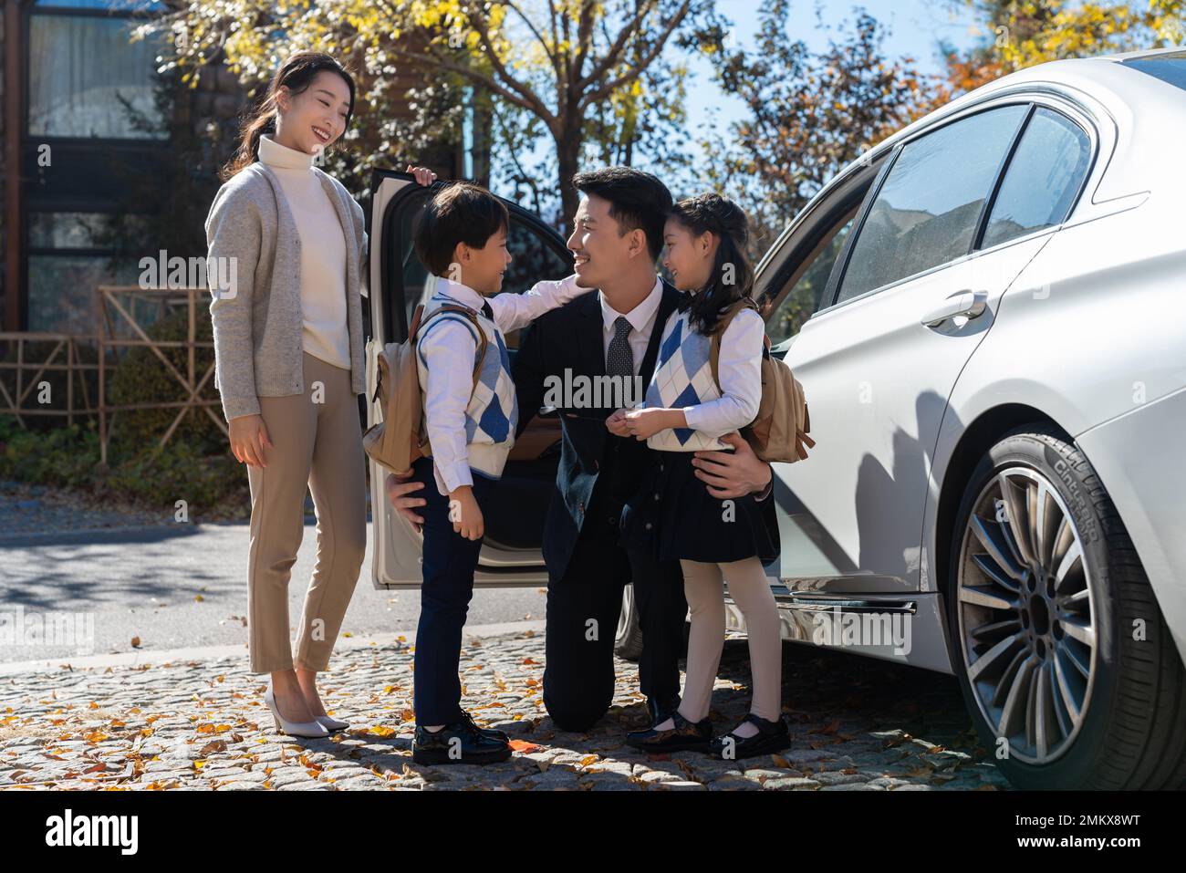 A young couple pick up the kids from school Stock Photo - Alamy