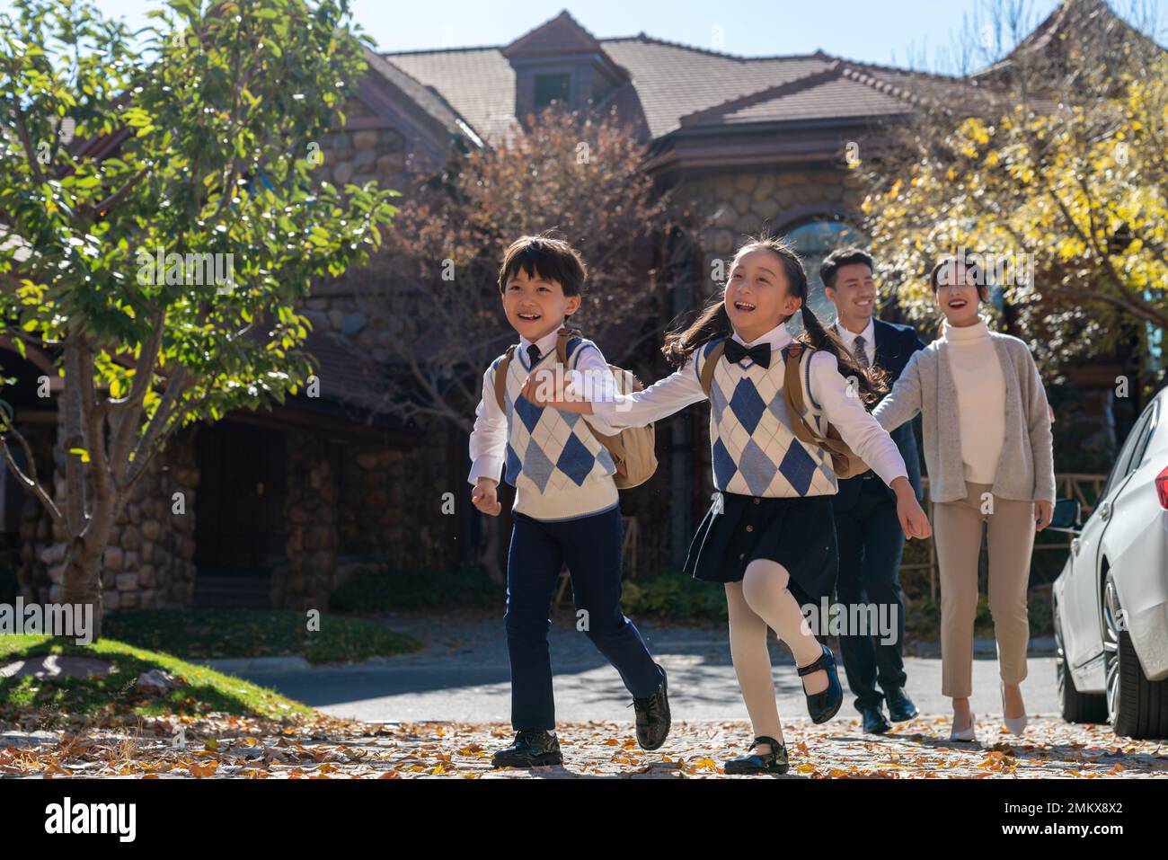 A young couple pick up the kids from school Stock Photo - Alamy