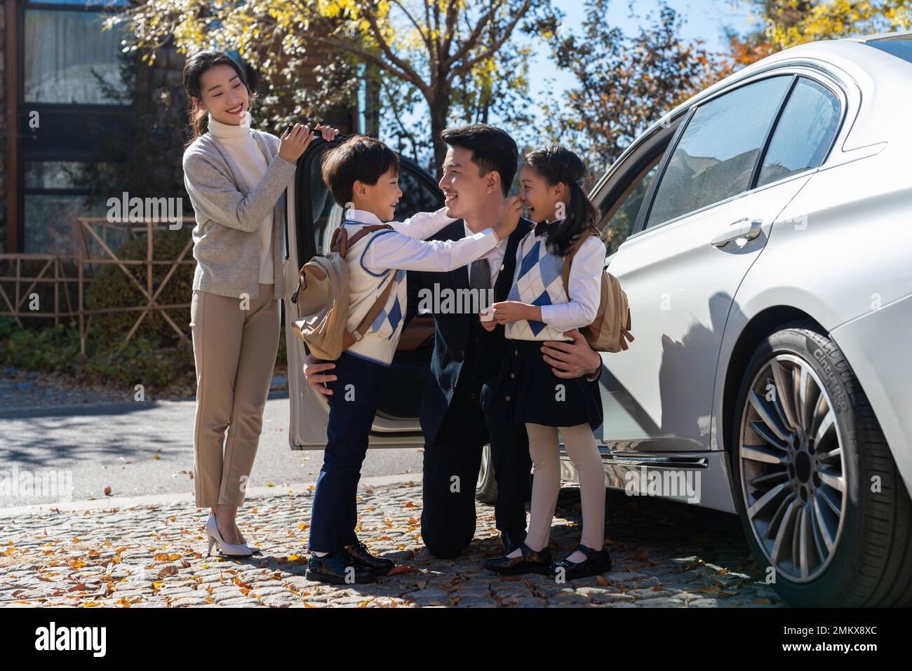 A young couple pick up the kids from school Stock Photo - Alamy