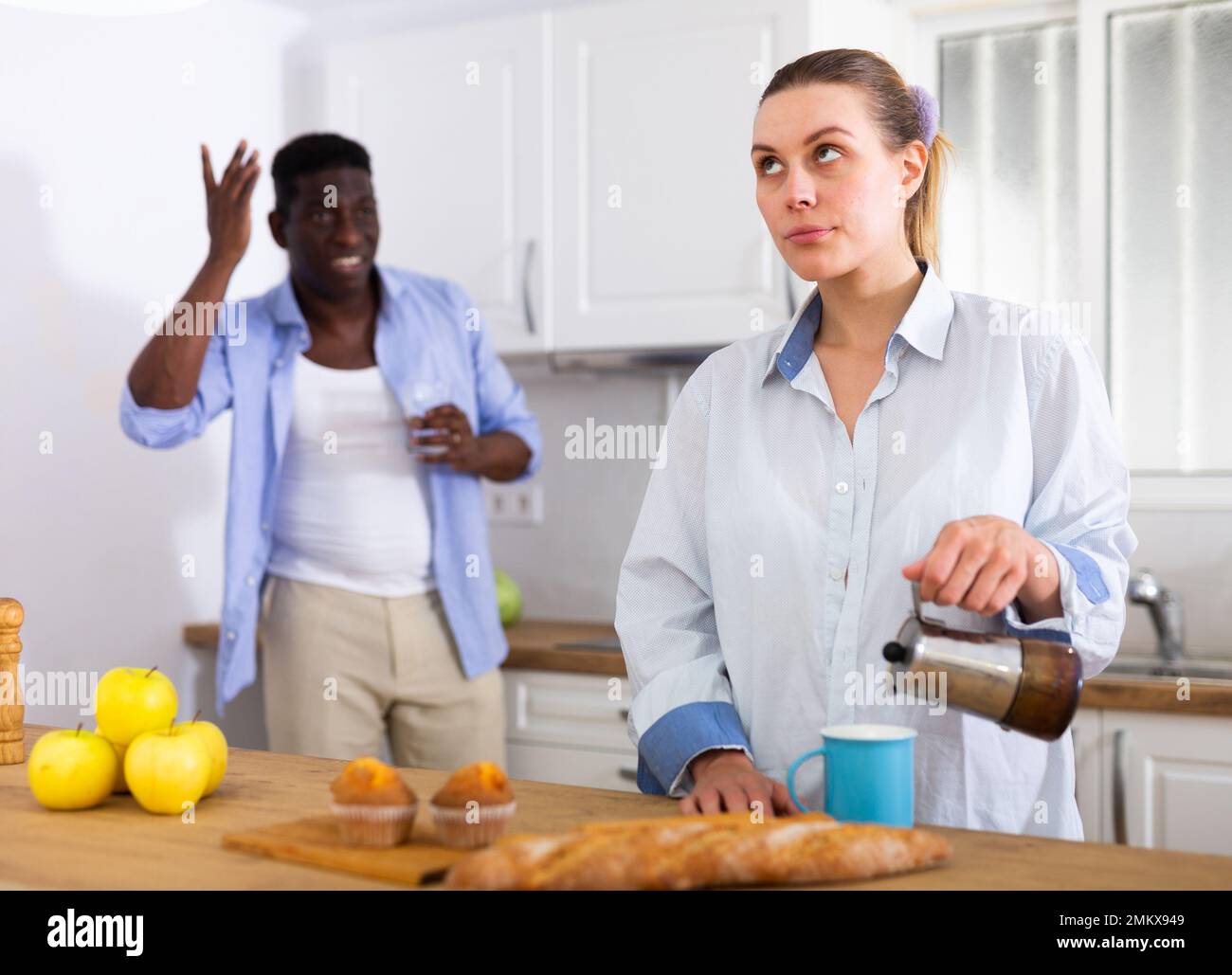 Upset young woman pouring coffee into cup on background of dissatisfied ...