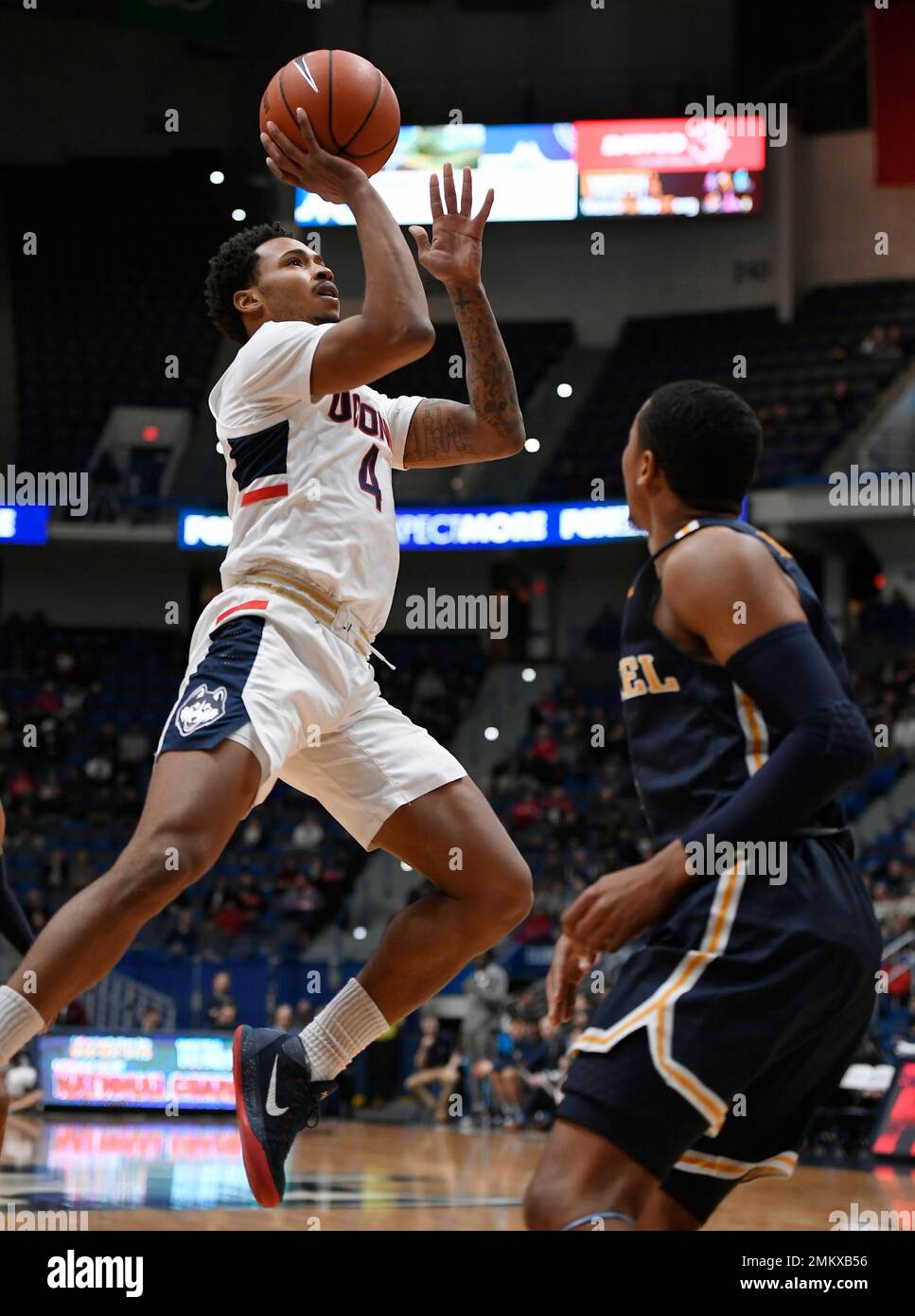 Connecticut's Jalen Adams (4) shoots as Drexel's Troy Harper looks on ...