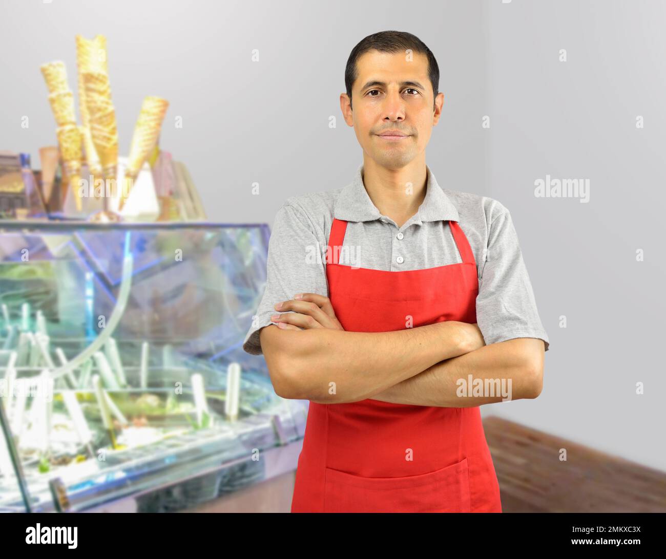 Smiling ice cream store employee standing behind the counter in the ...