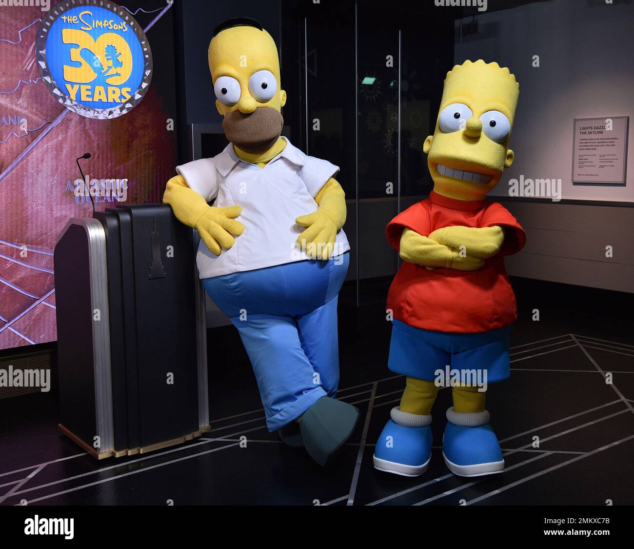 Costume characters Homer Simpson, left, and Bart Simpson participate in ...