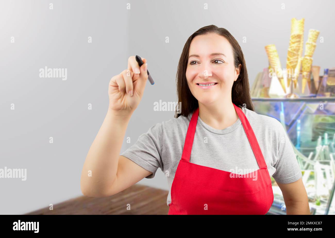 Smiling ice cream store employee standing behind the counter in the ...