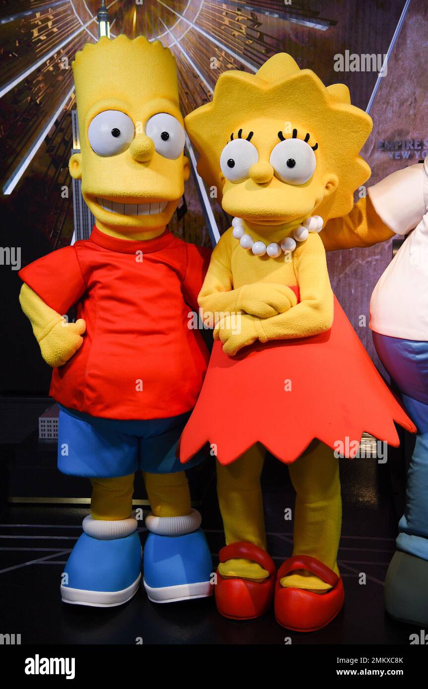 Costumed character Bart Simpson, left, and Lisa Simpson participate in ...