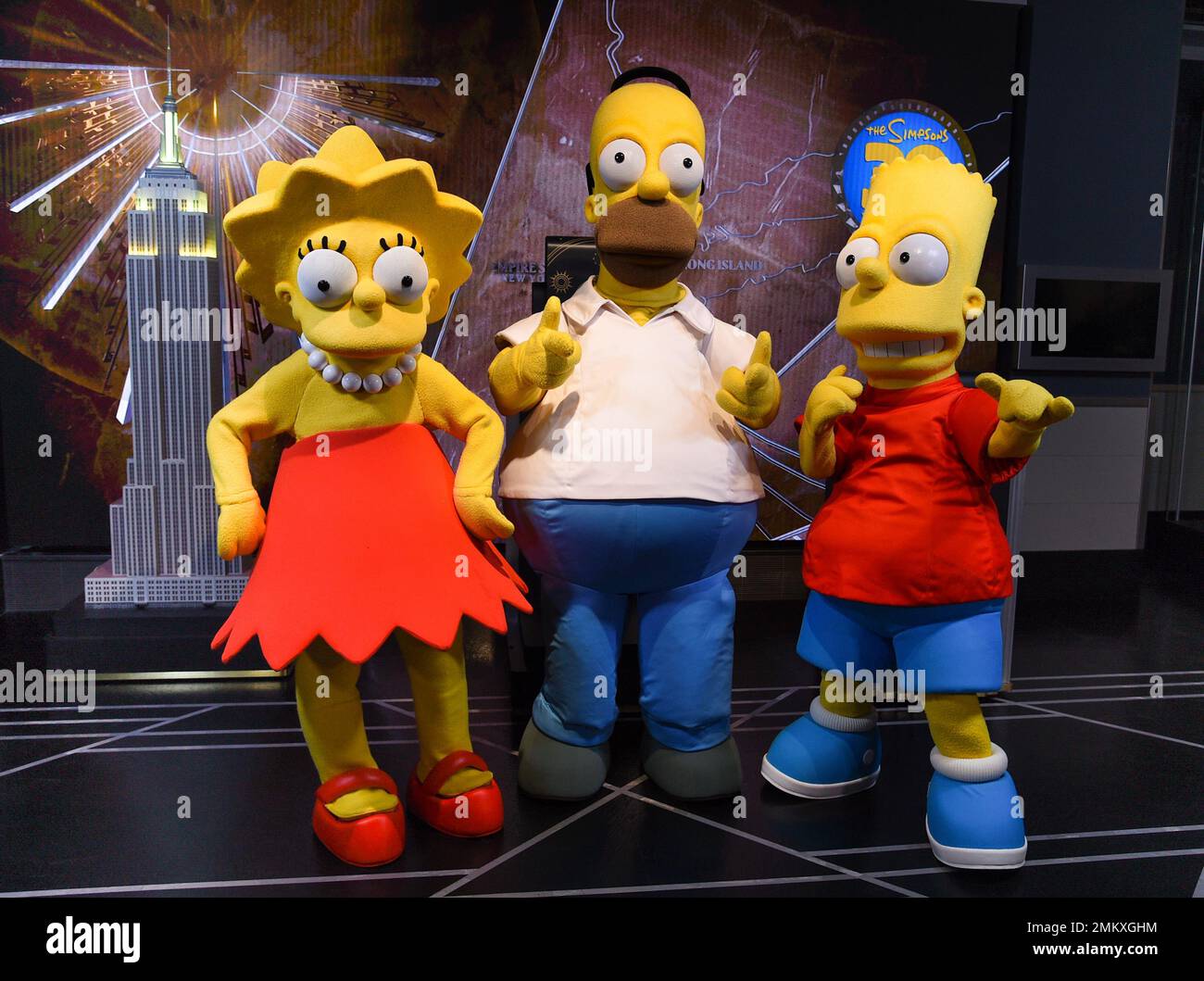 Costumed characters Lisa Simpson, left, Homer Simpson and Bart Simpson ...