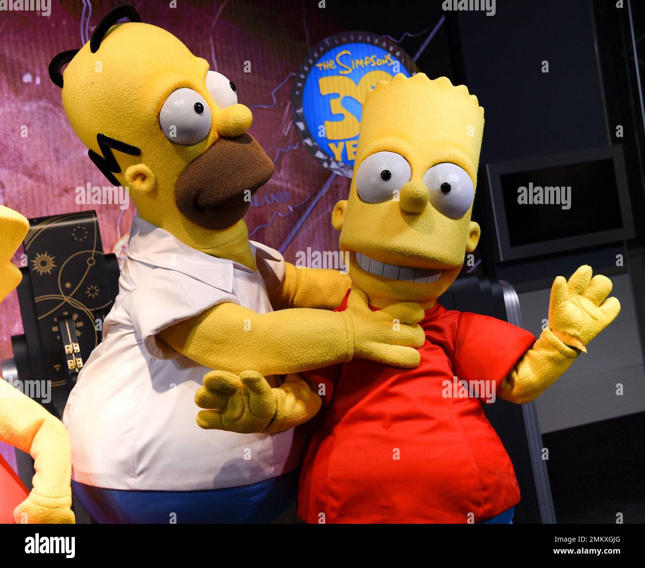 Costume characters Homer Simpson, left, and Bart Simpson participate in ...