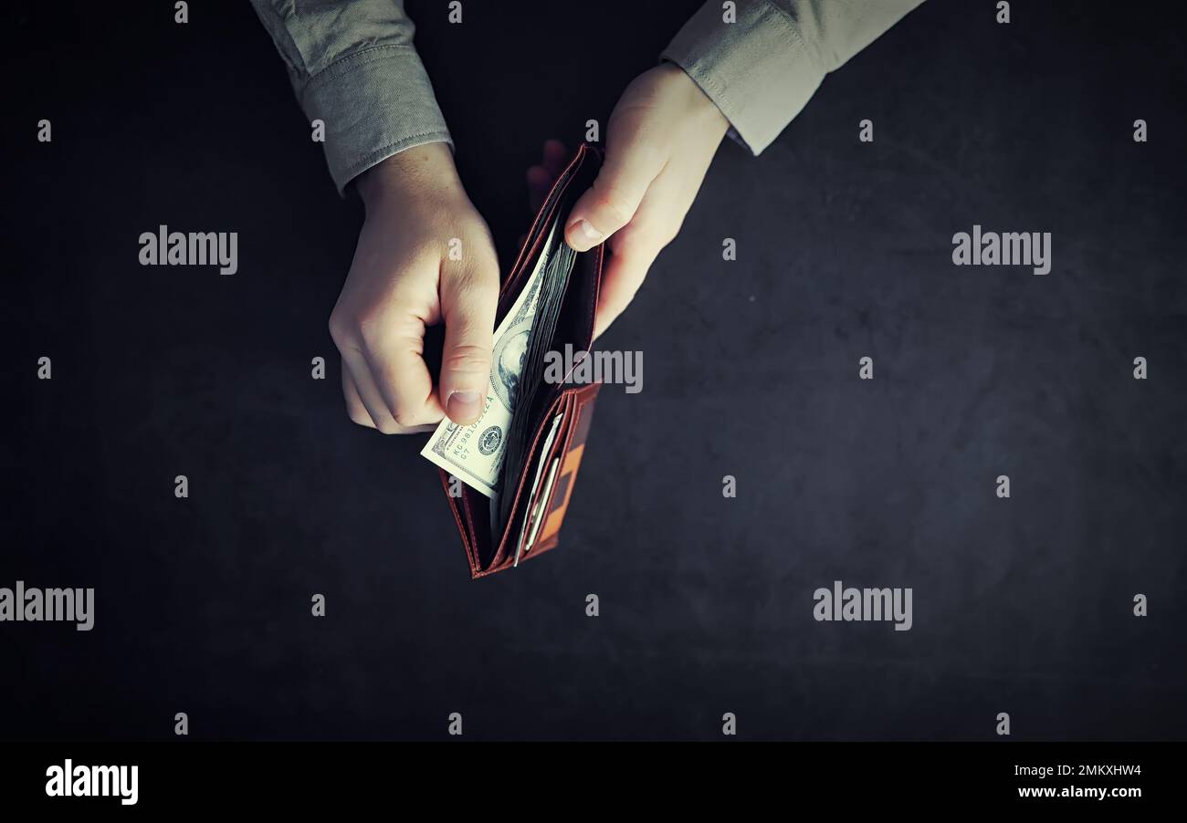 Hands take out cash banknotes from a wallet on gray background. Foreign ...