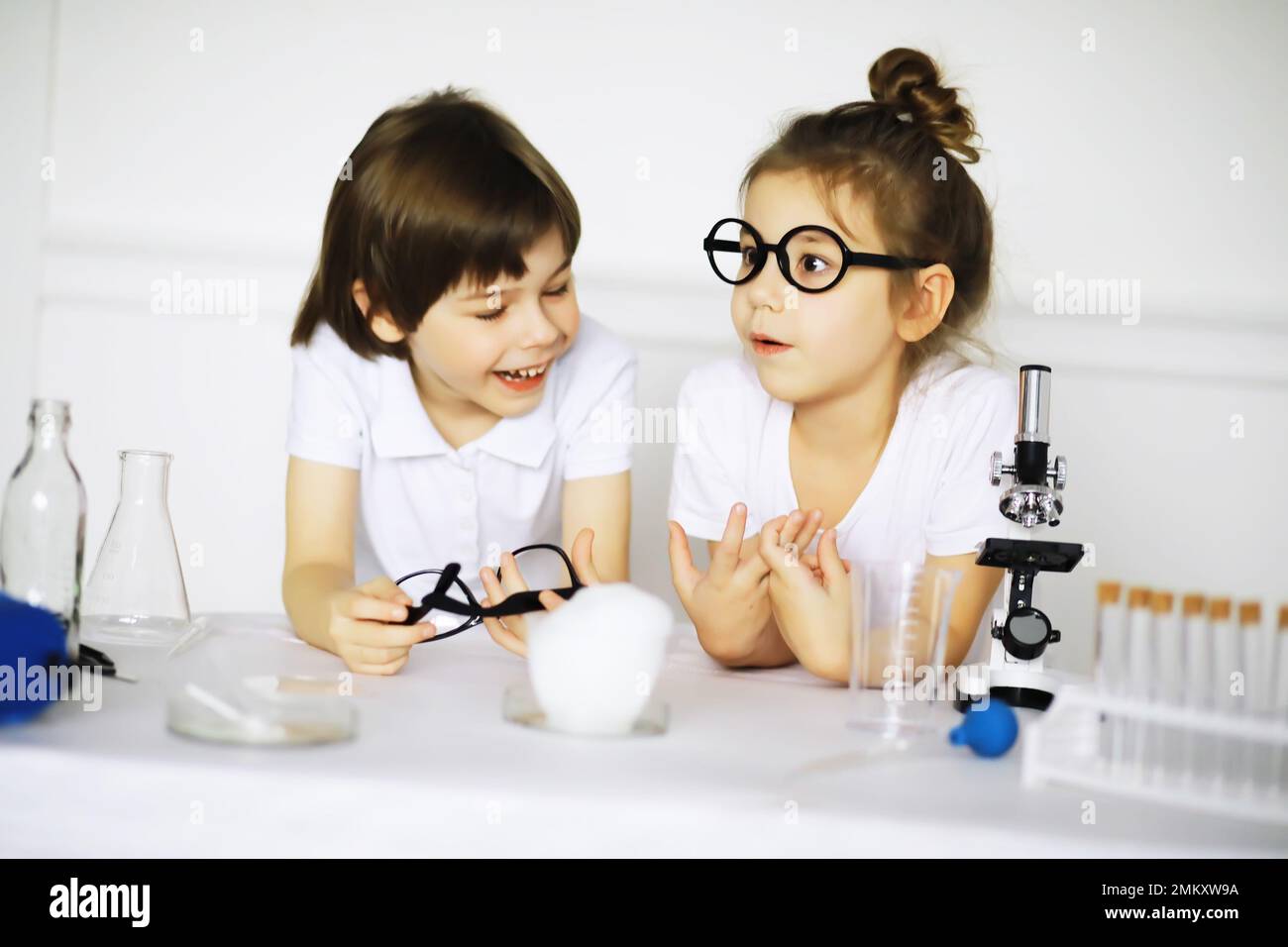 Two cute children at chemistry lesson making experiments isolated on ...