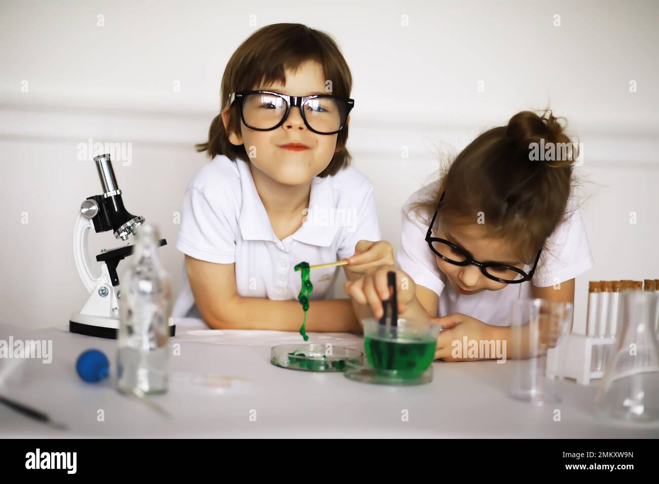 Two cute children at chemistry lesson making experiments isolated on ...