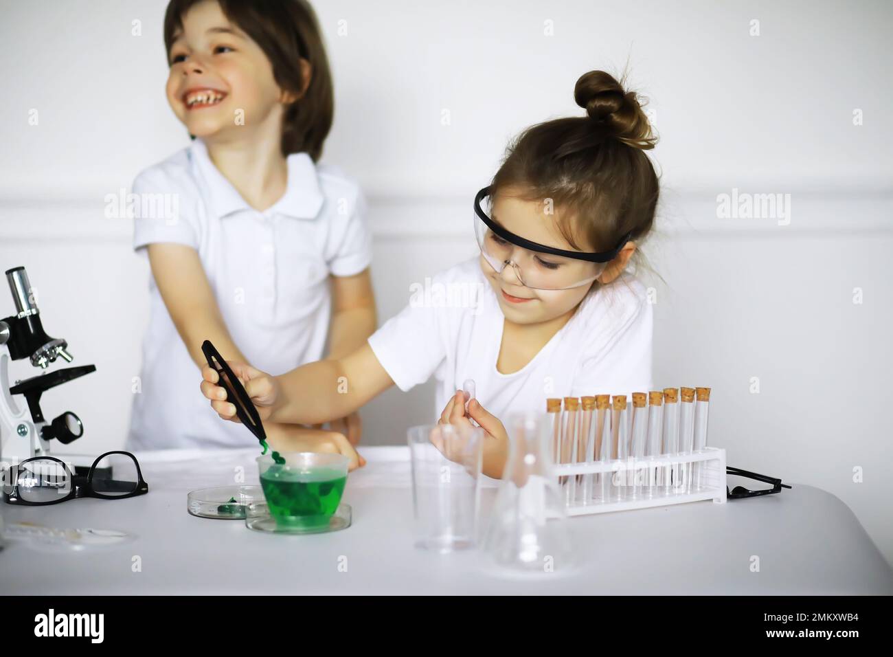 Two cute children at chemistry lesson making experiments isolated on ...