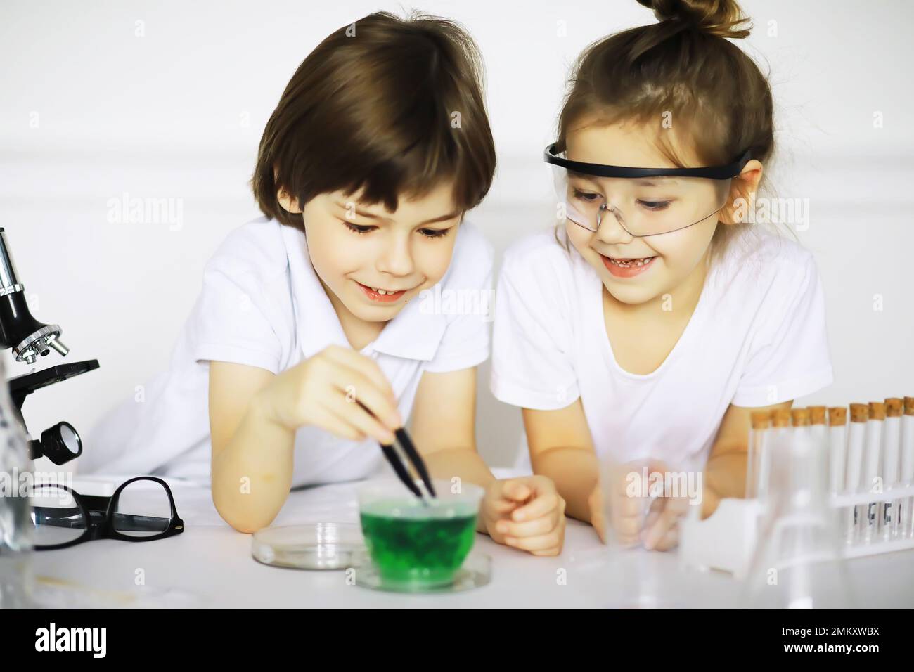 Two cute children at chemistry lesson making experiments isolated on ...