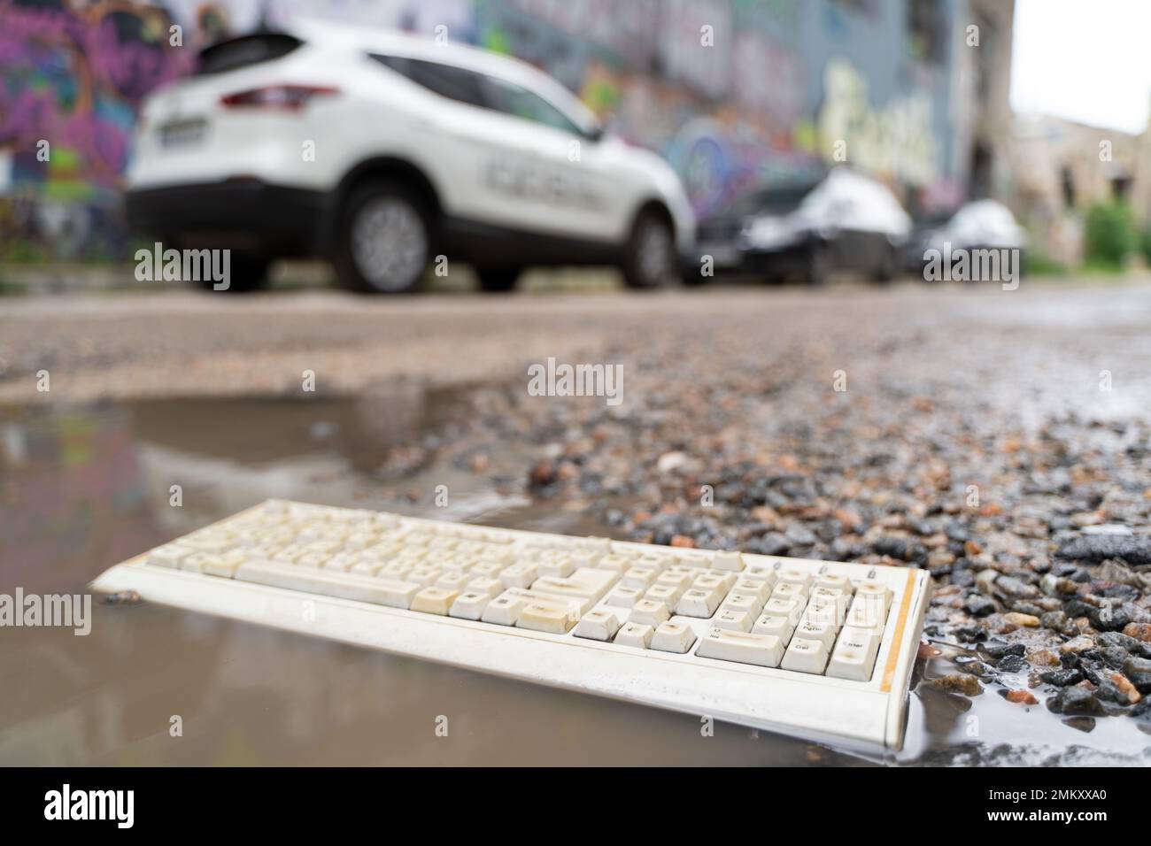 old broken computer keyboard, thrown into the trash lying on the road ...