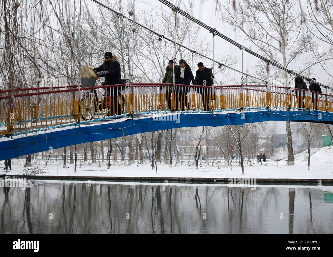 North Koreans walk on a pedestrian bridge that crosses Pothong River in ...