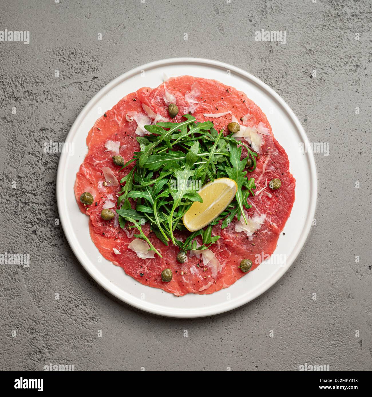 Beef carpaccio with capers, arugula and parmesan Stock Photo - Alamy