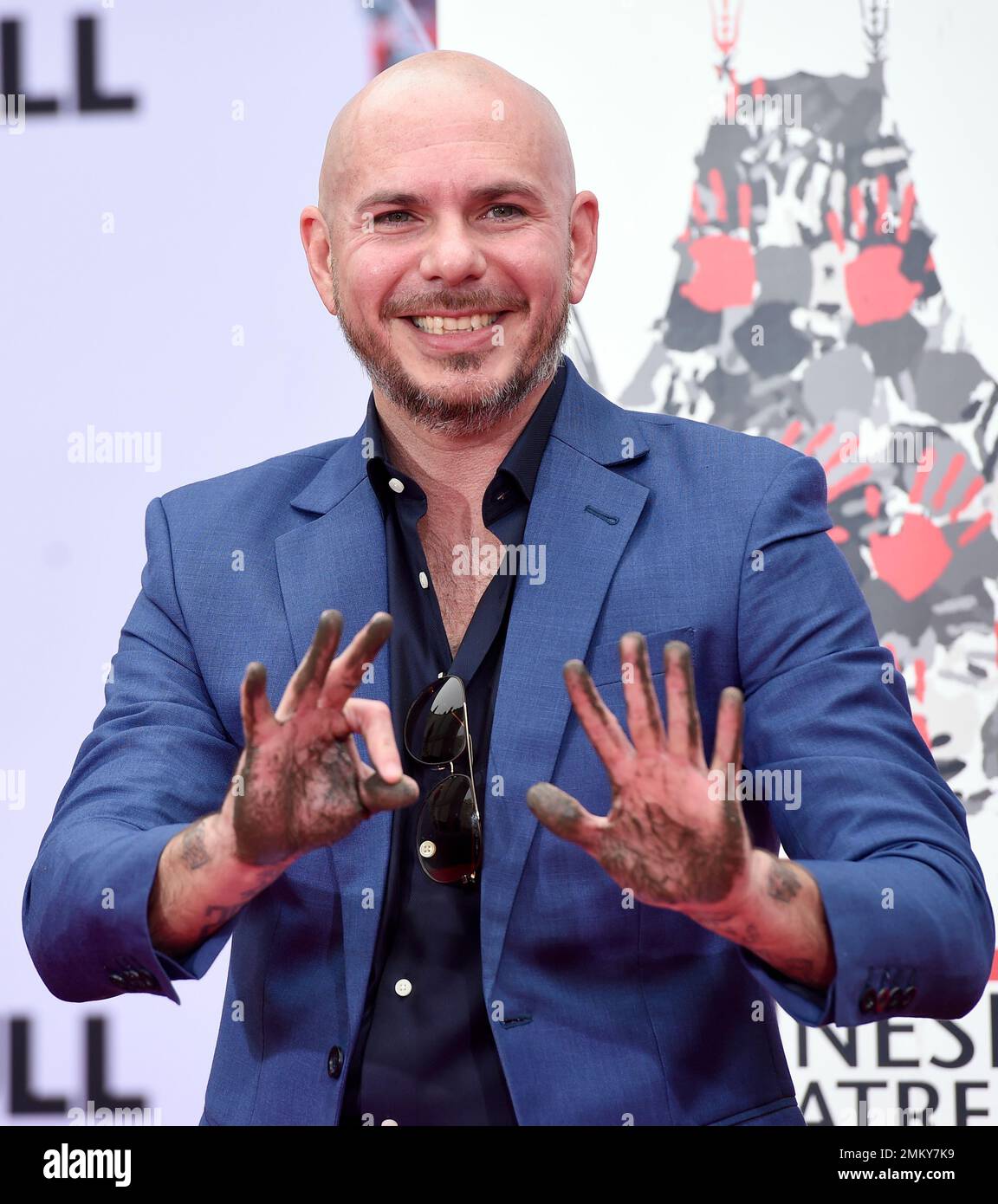 Rapper Pitbull holds up his hands after placing them in cement during a ...