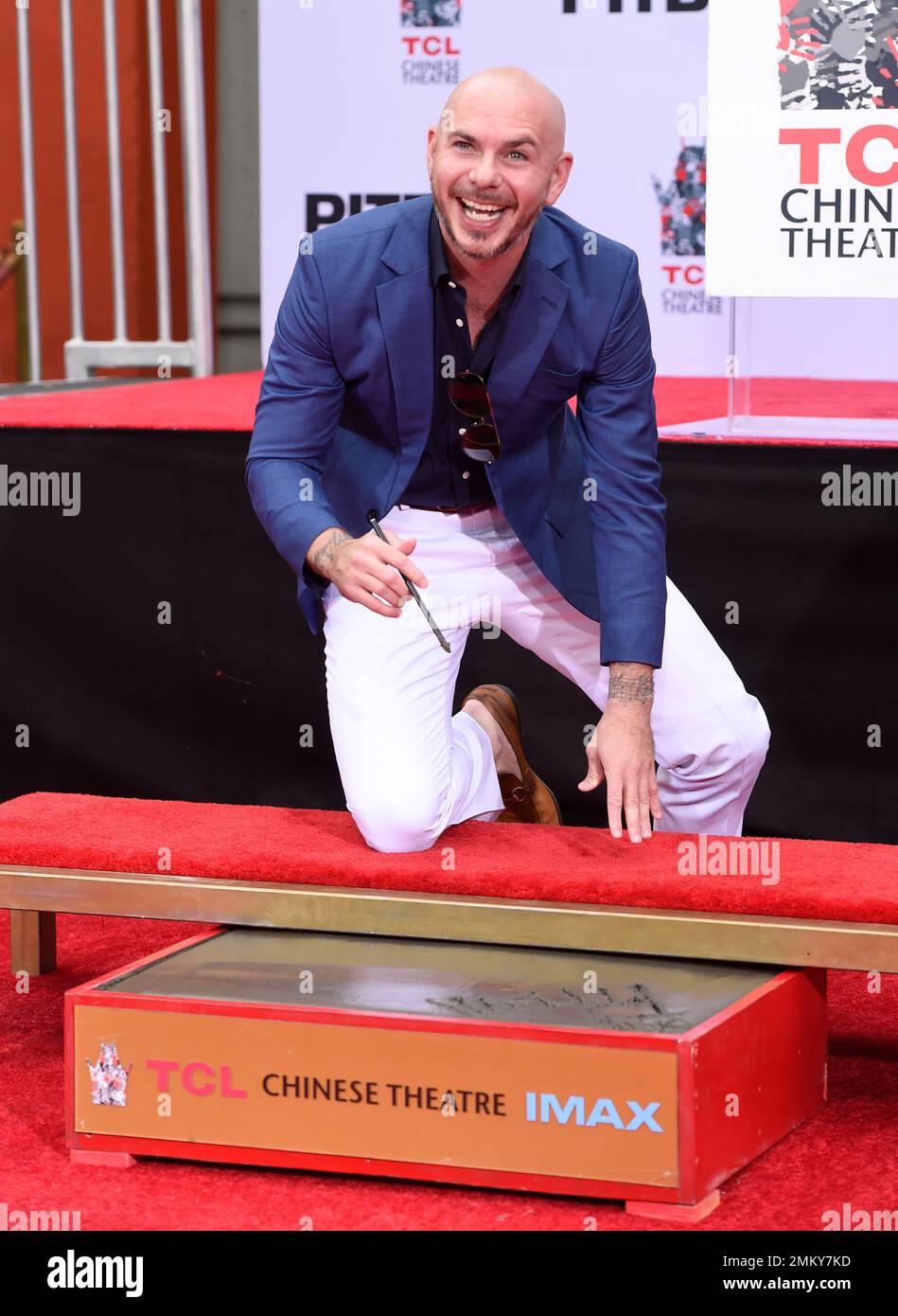 Rapper Pitbull poses while signing his name in cement during a hand and ...