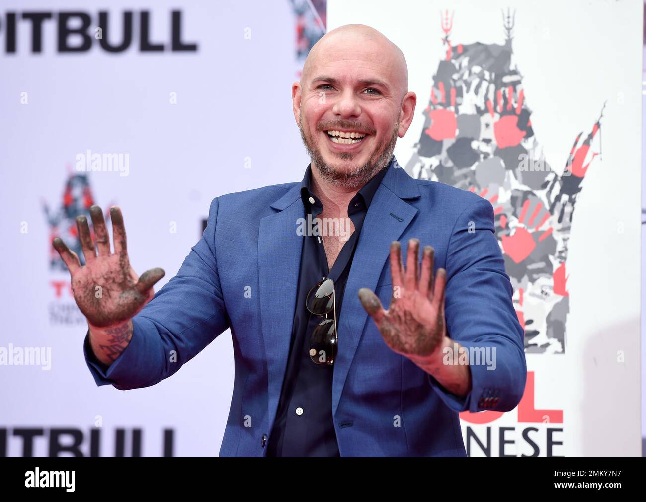 Rapper Pitbull holds up his hands after placing them in cement during a ...