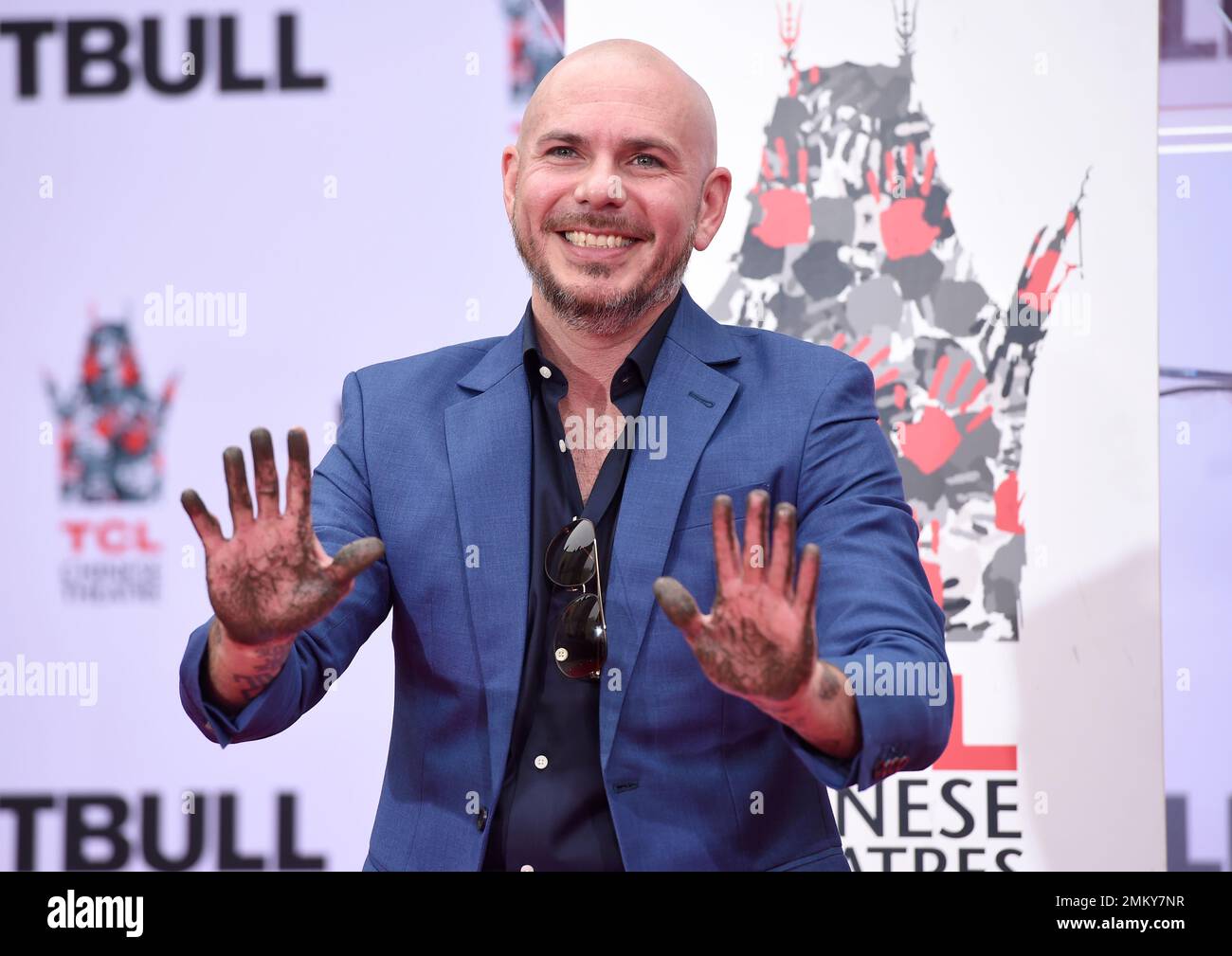 Rapper Pitbull holds up his hands after placing them in cement during a ...
