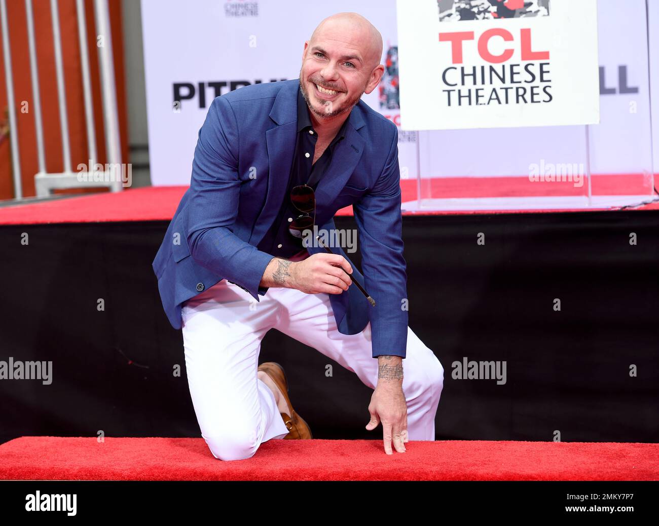 Rapper Pitbull poses while signing his name in cement during a hand and ...