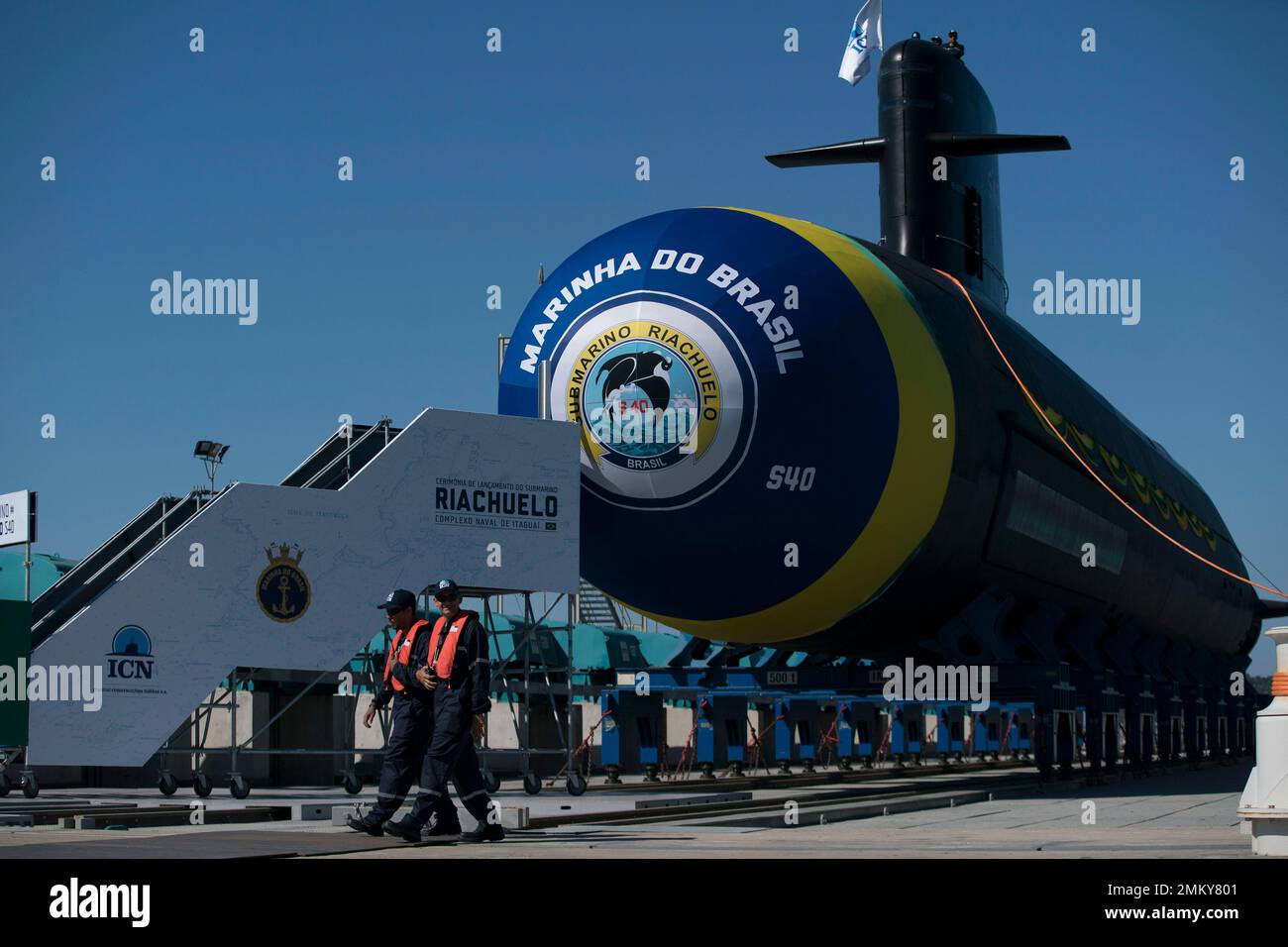 Workers walk past the Brazilian submarine Riachuelo before its ...