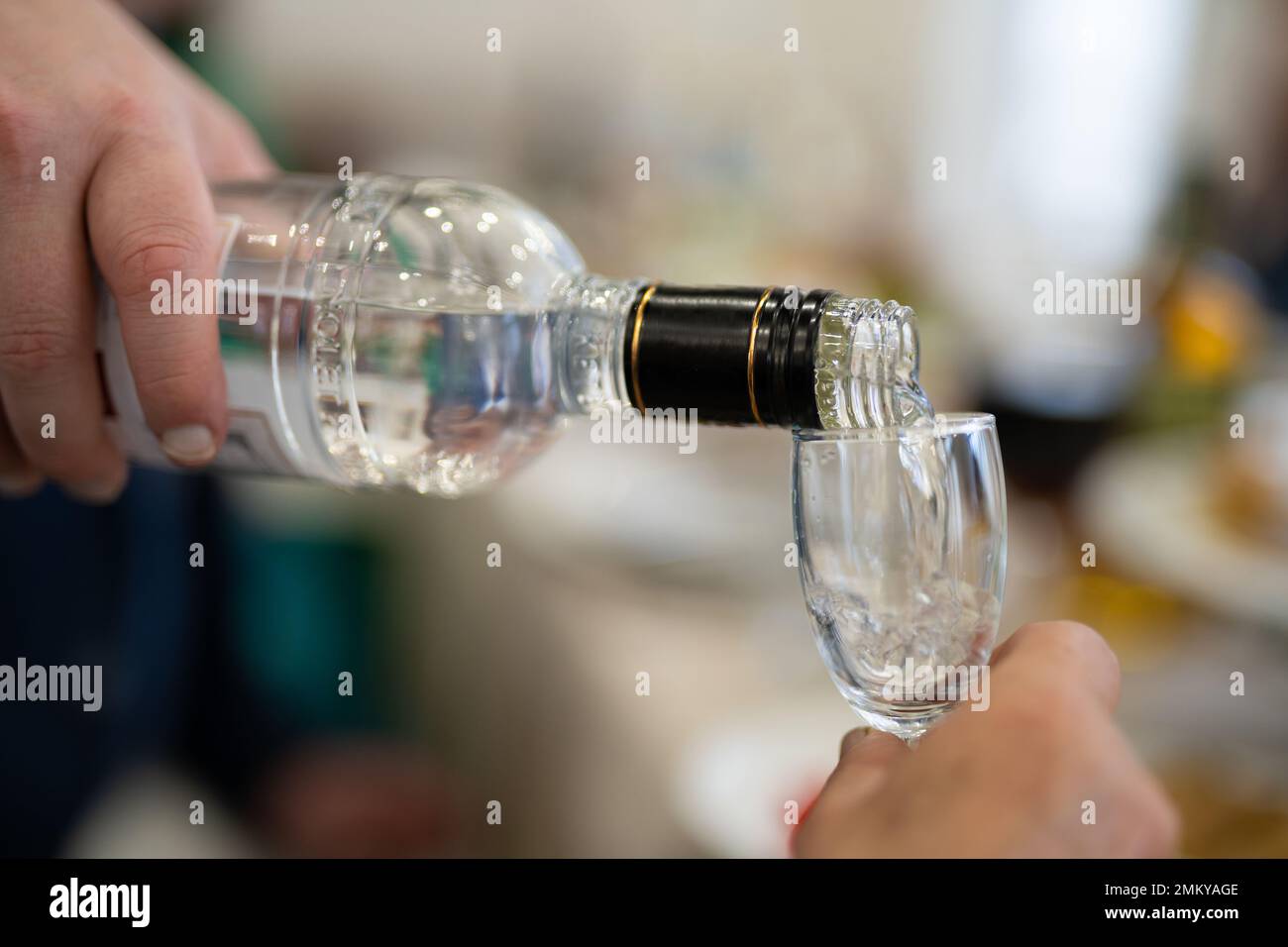 the waiter pours an alcoholic drink, vodka into a glass Stock Photo - Alamy