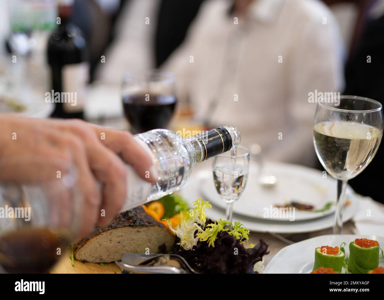 the waiter pours an alcoholic drink, vodka into a glass Stock Photo - Alamy