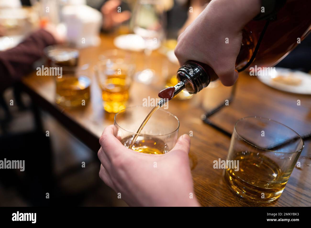 the bartender pours alcohol from the bottle Stock Photo - Alamy