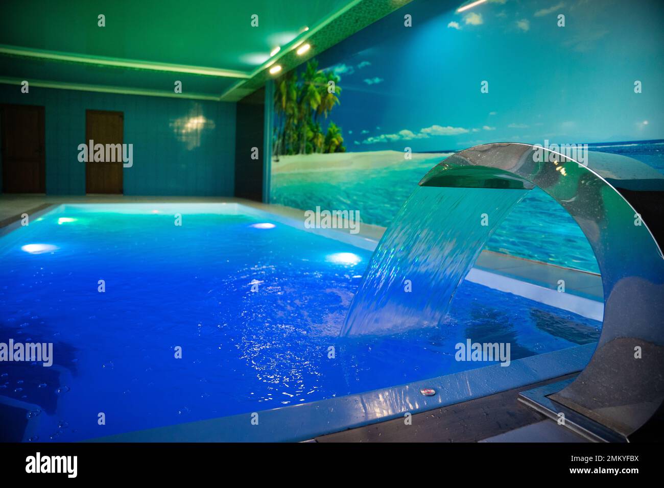 a modern large indoor pool with blue lighting and a waterfall Stock ...