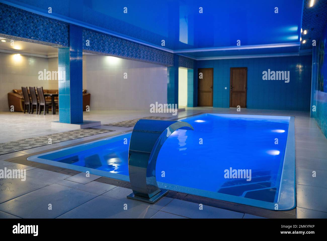 a modern large indoor pool with blue lighting and a waterfall Stock ...