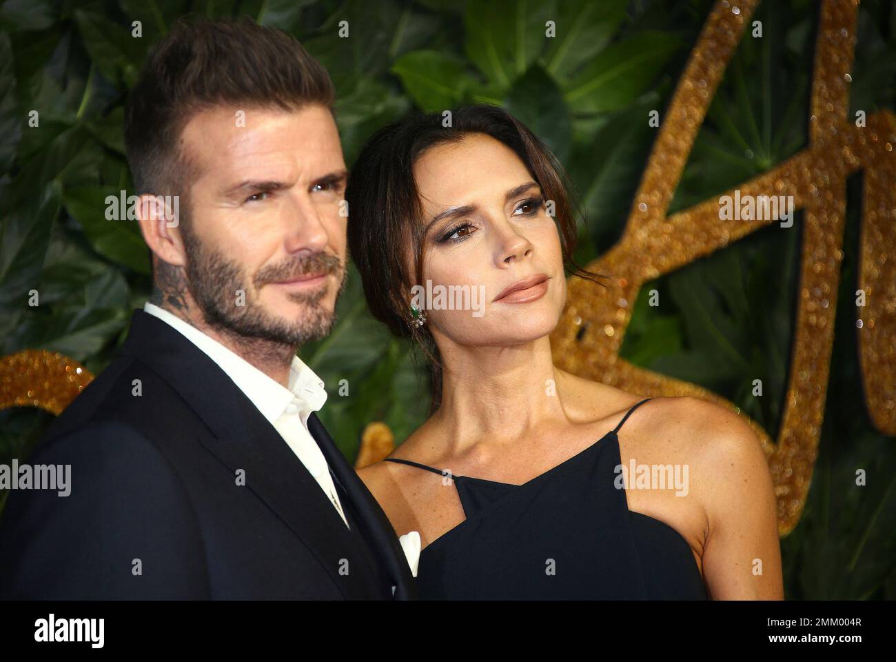 Former soccer player David Beckham, left, and designer Victoria Beckham pose for photographers ...