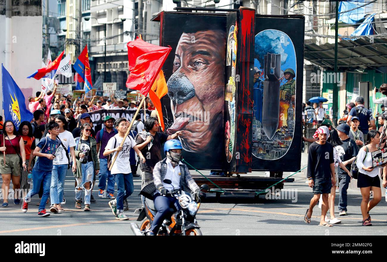 Protesters march with a rotating effigy of Philippine President Rodrigo ...