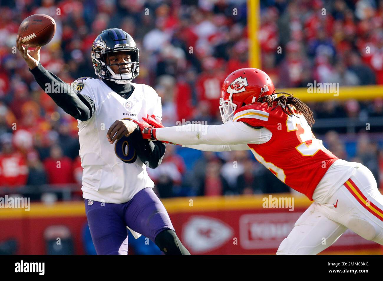Baltimore Ravens quarterback Lamar Jackson, left, throws under pressure ...