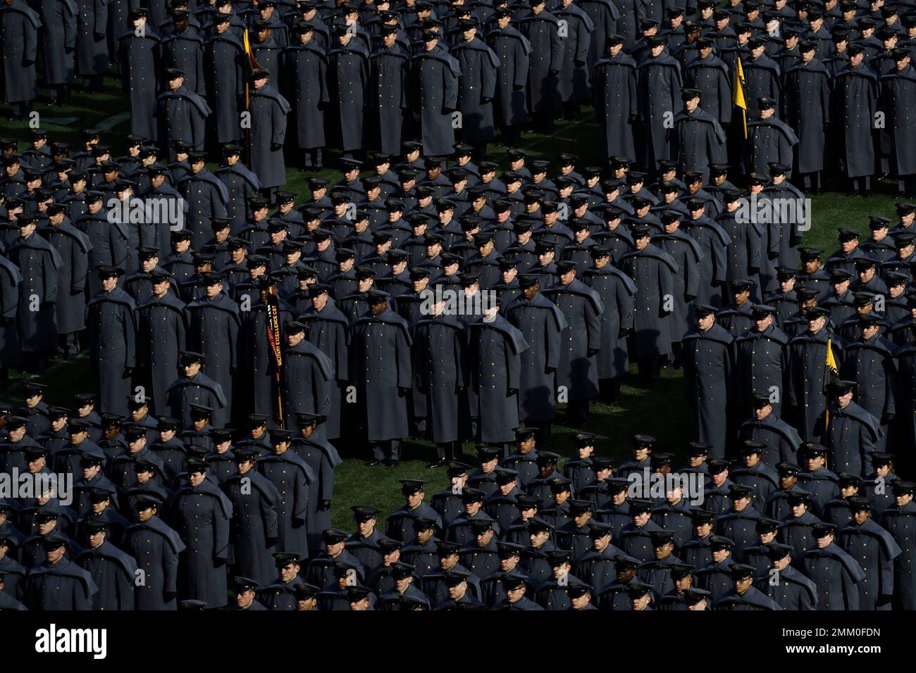Army cadets stand at attention after marching onto the field before an ...