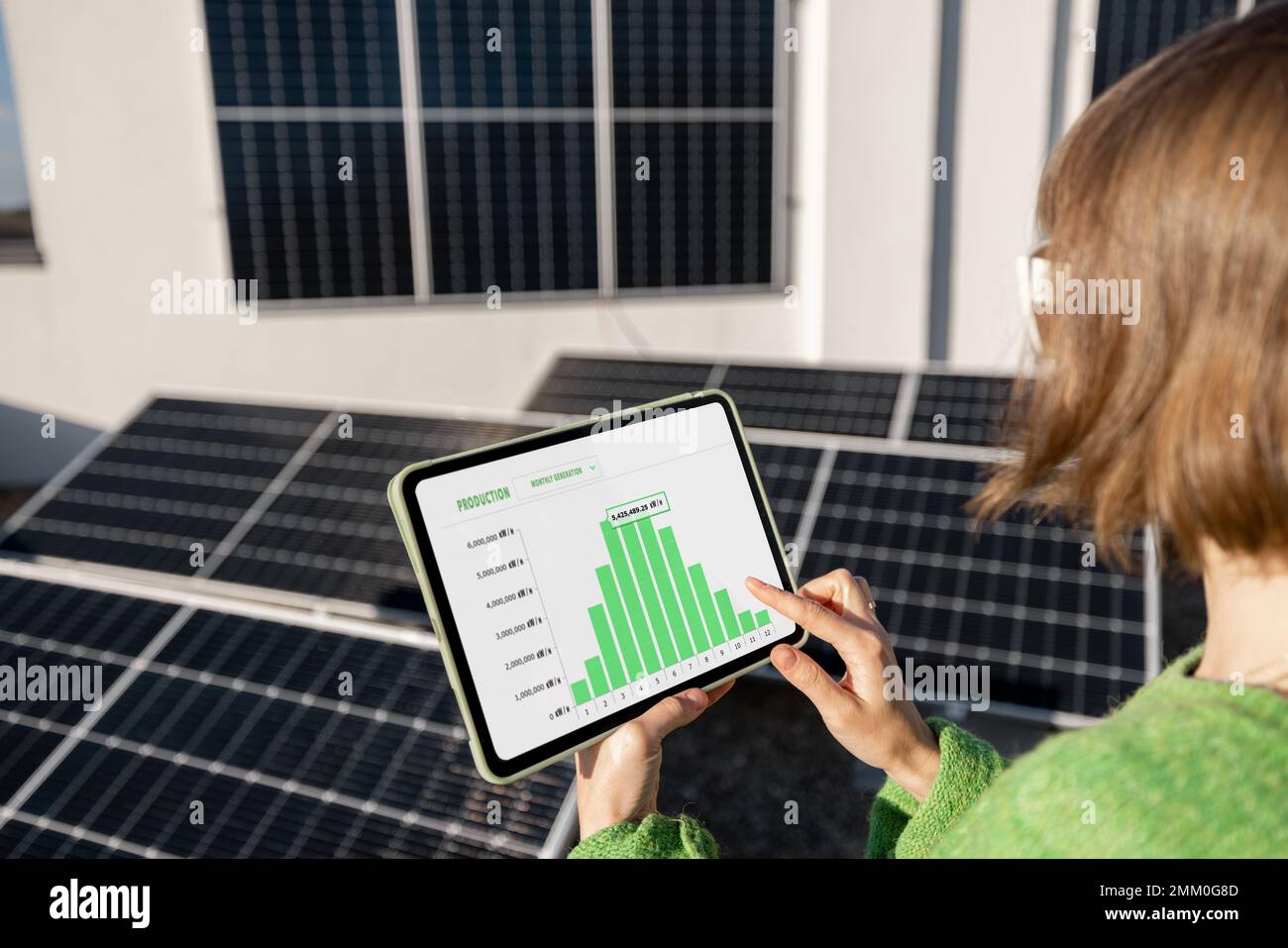 Woman monitors energy production from the solar power plant with a ...