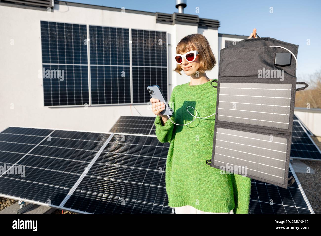 Woman charging phone from a solar portable panel Stock Photo - Alamy