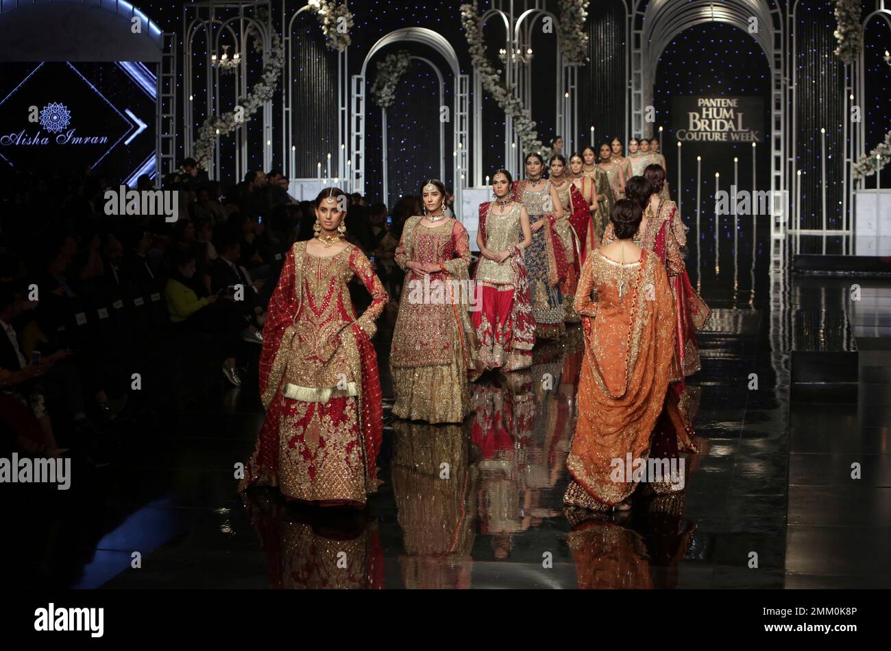 Models present the creations by designer Aisha Imran during Bridal ...