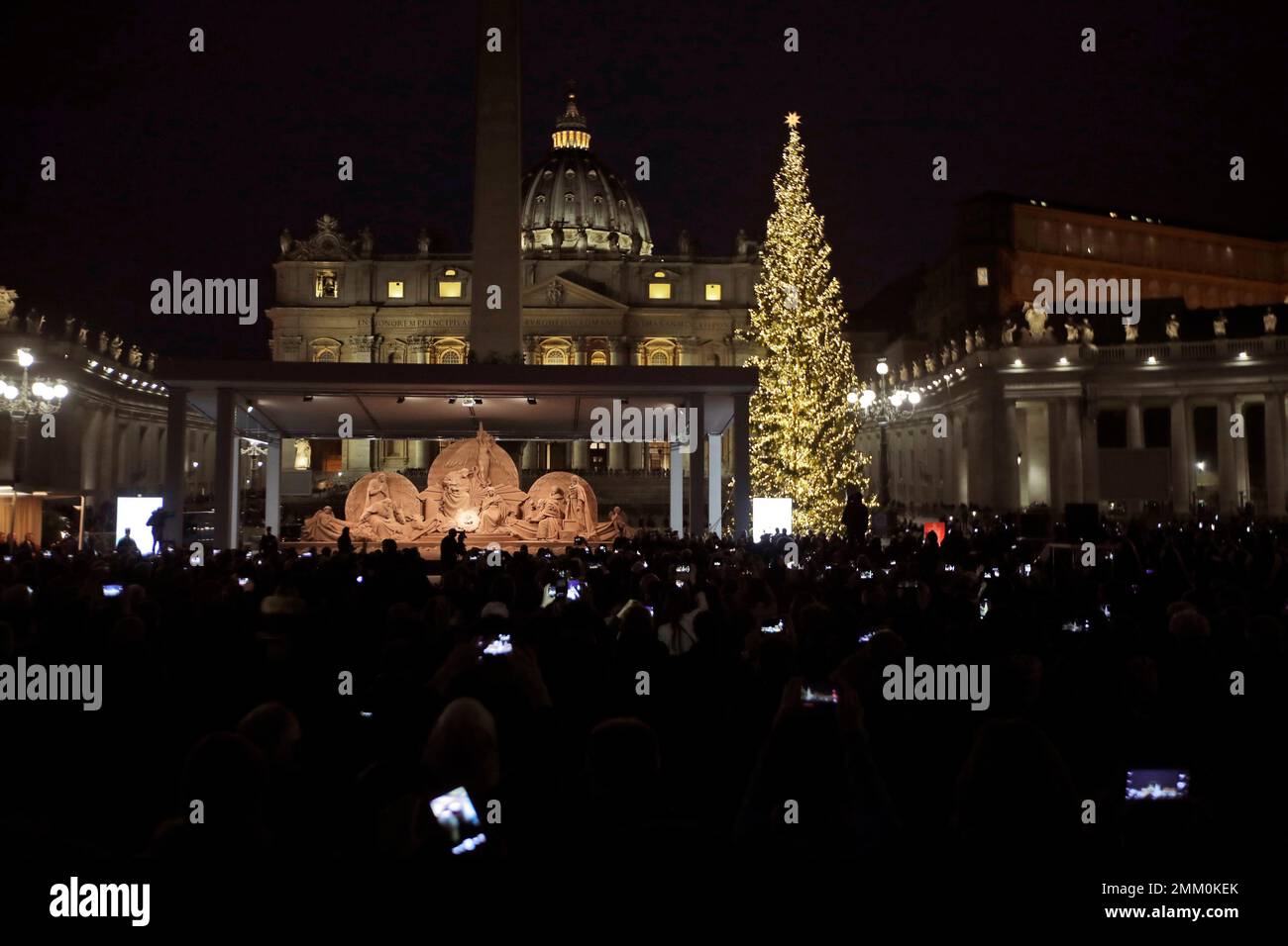 A Nativity scene and a Christmas Tree are backdropped by St. Peter's ...