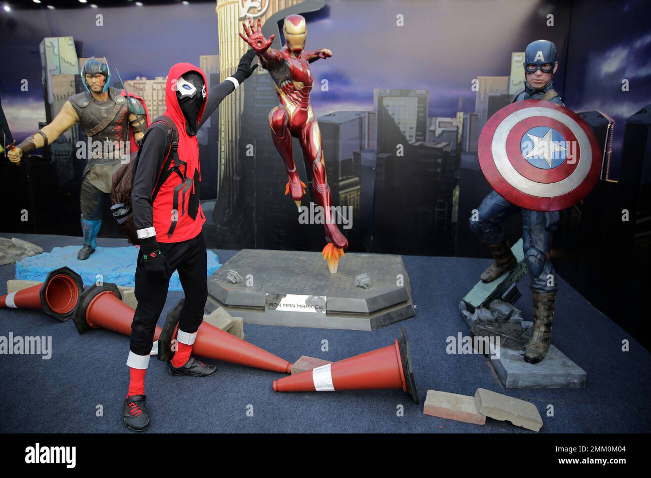 A fan poses in front of his favorite comic characters from Marvel ...