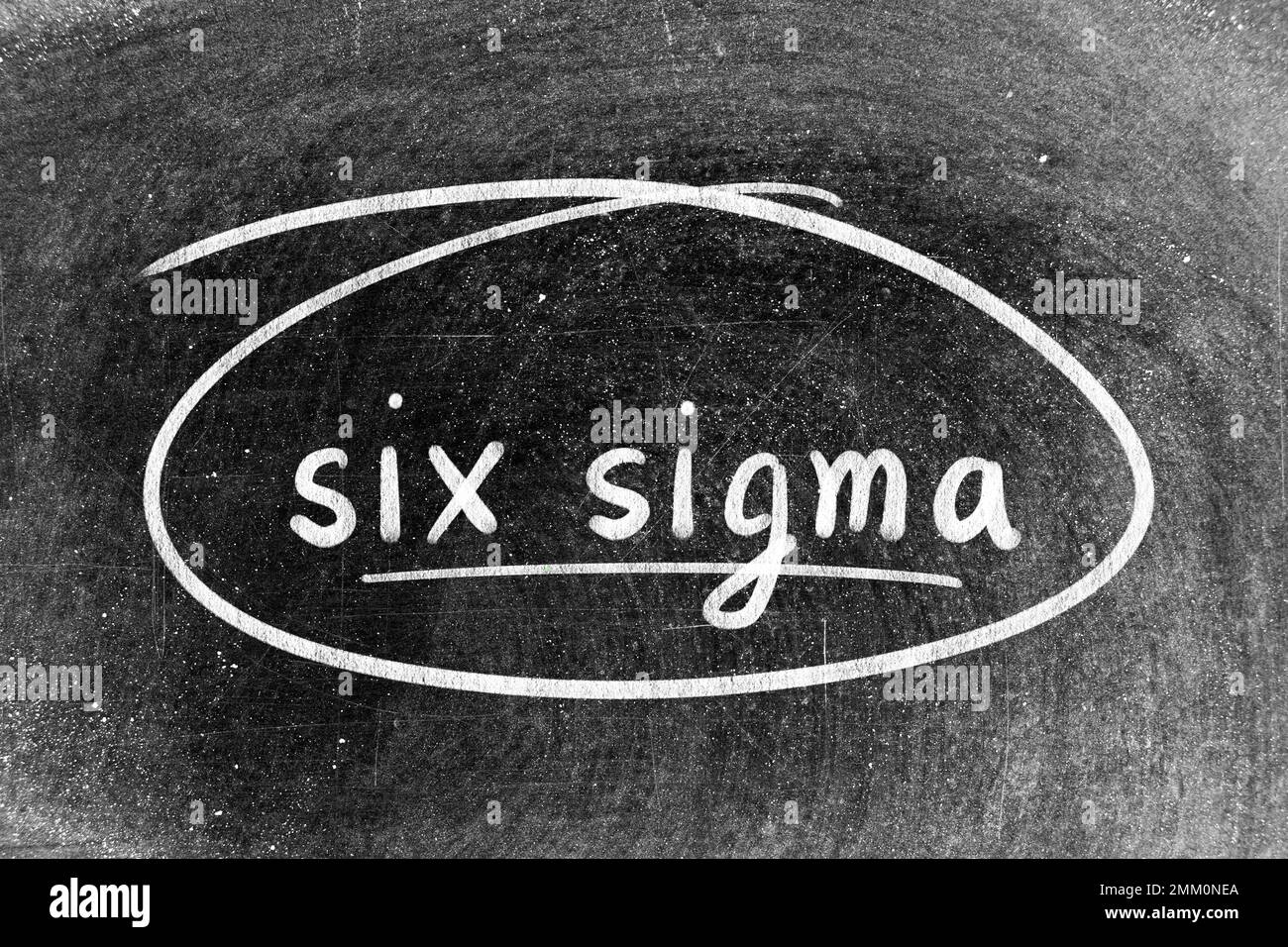 White chalk hand writing in word six sigma and circle shape on ...