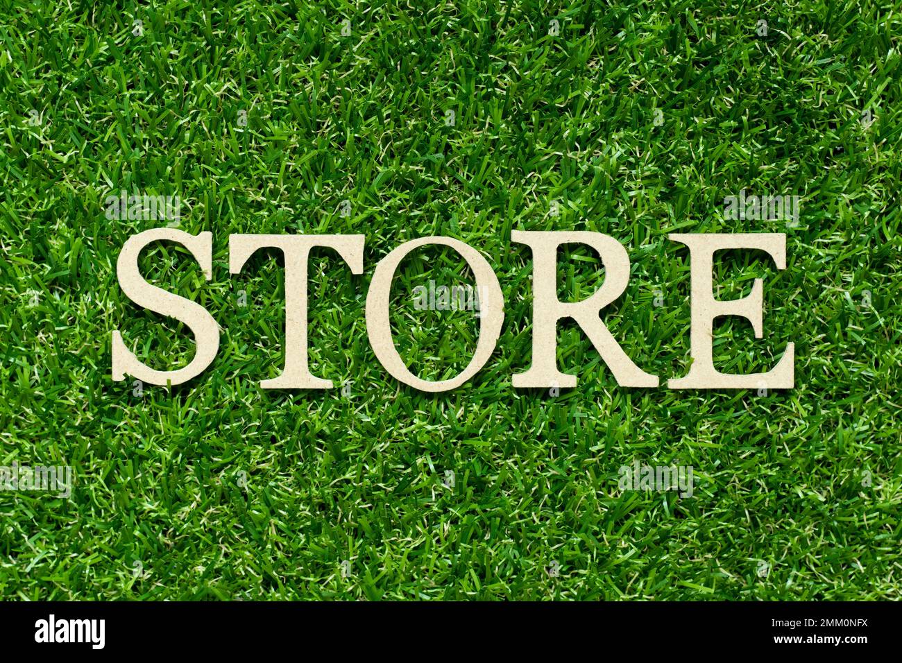 Wood letter in word store on green grass background Stock Photo - Alamy