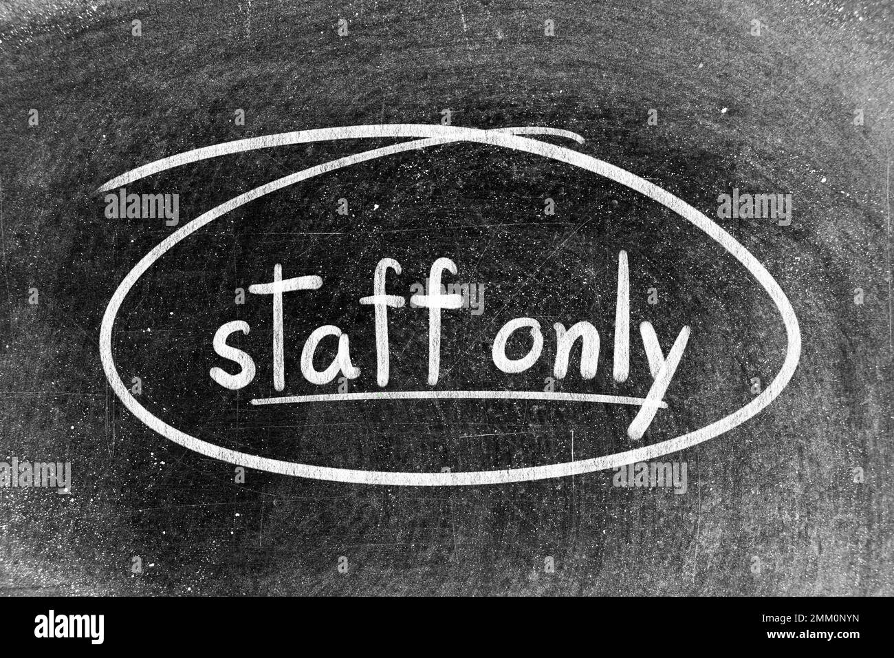 White chalk hand writing in word staff only and circle shape on ...