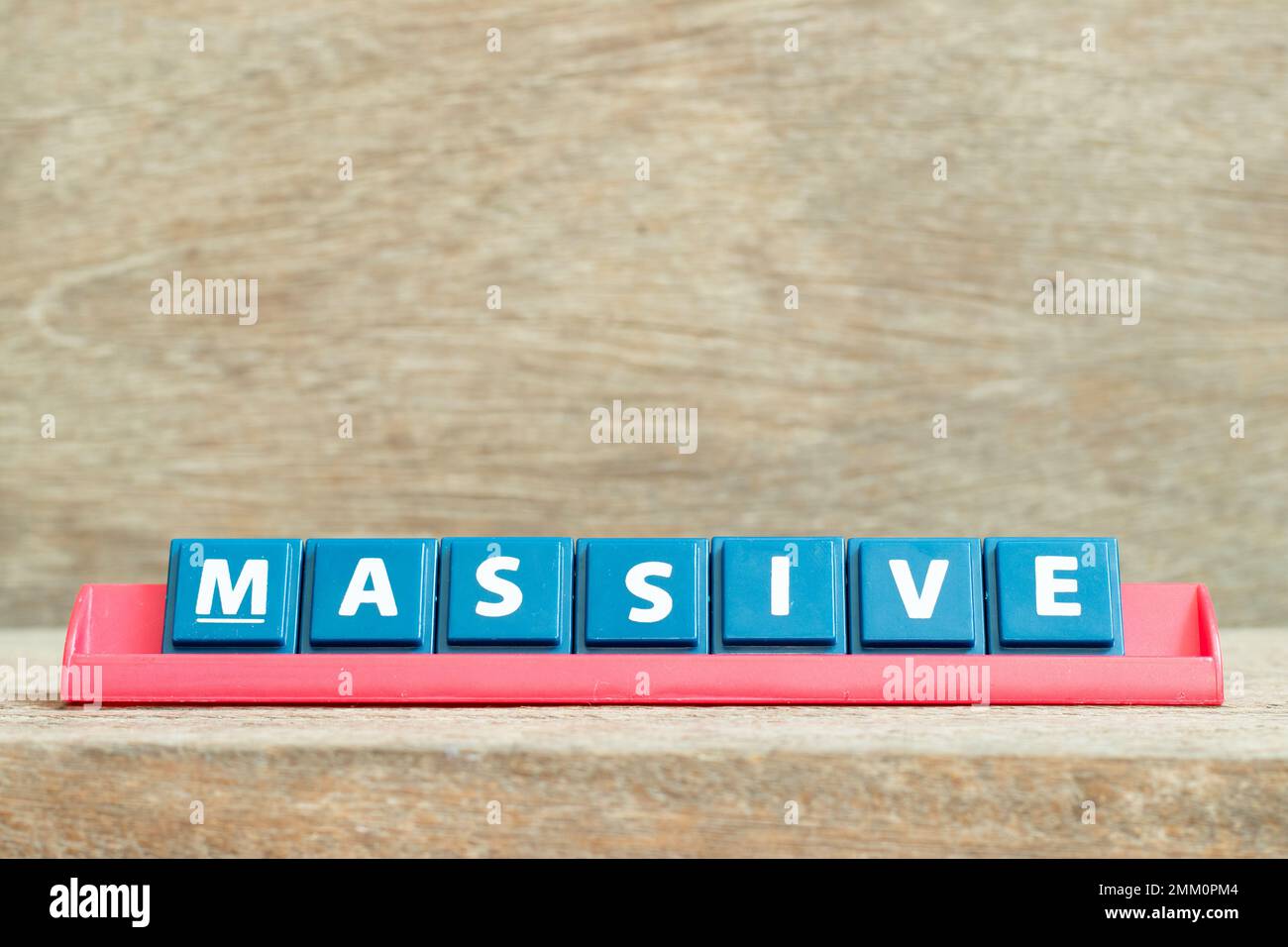 Tile alphabet letter with word massive in red color rack on wood ...