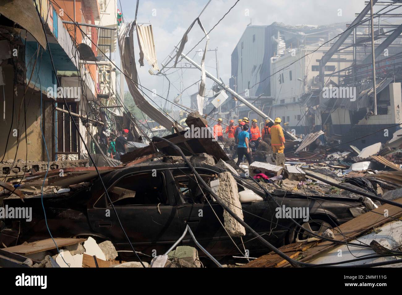Search and rescue stand in the debris caused by an explosion at the ...