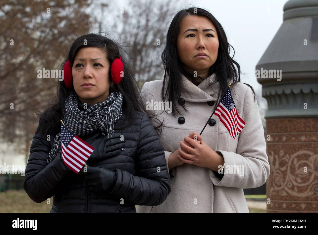 Stephanie Penn, left, and Tiffany Ge watch the flag-draped casket of ...