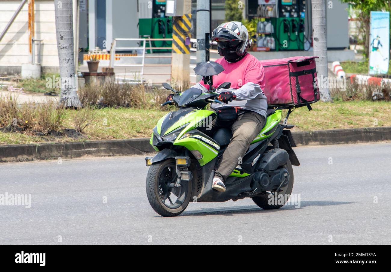 A delivery worker rides a motorcycle with a delivery box Stock Photo ...