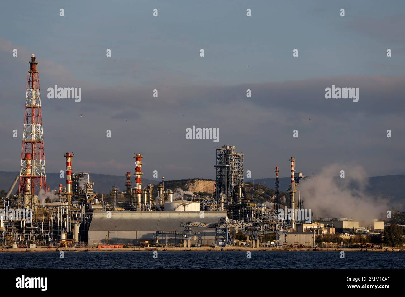Smoke is emitted from the chimneys of a refinery in Elefsina, west of ...